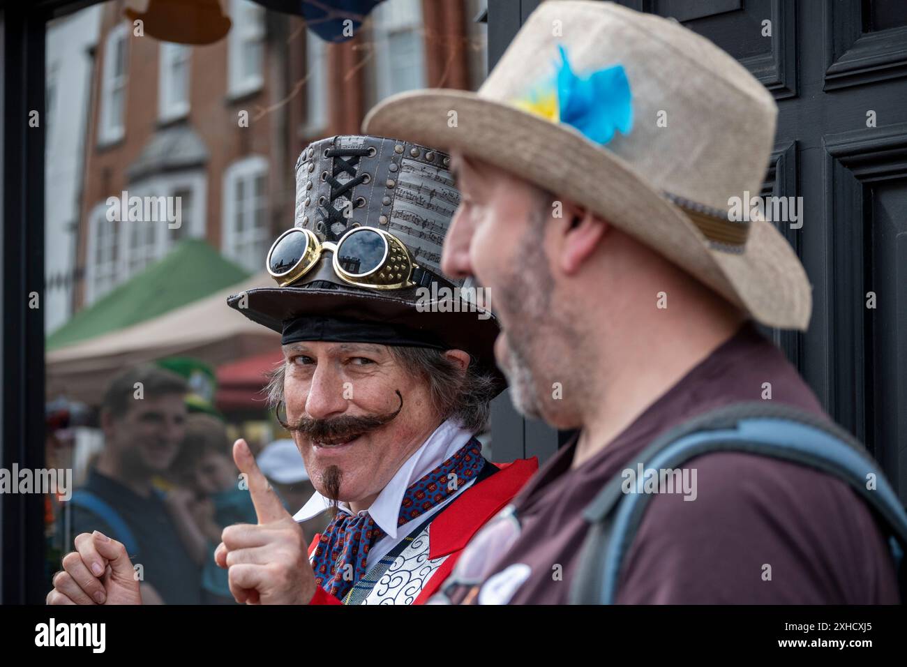 Chesham, UK. 13 July 2024. A street performer wearing a hat entertains ...
