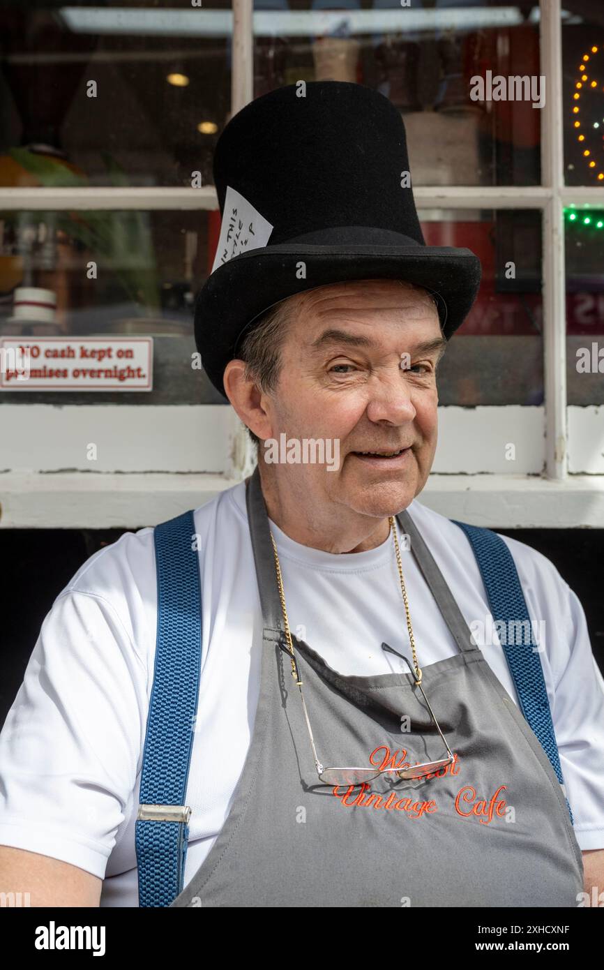 Chesham, UK. 13 July 2024. A shop owner wearing a hat at Hats Off ...