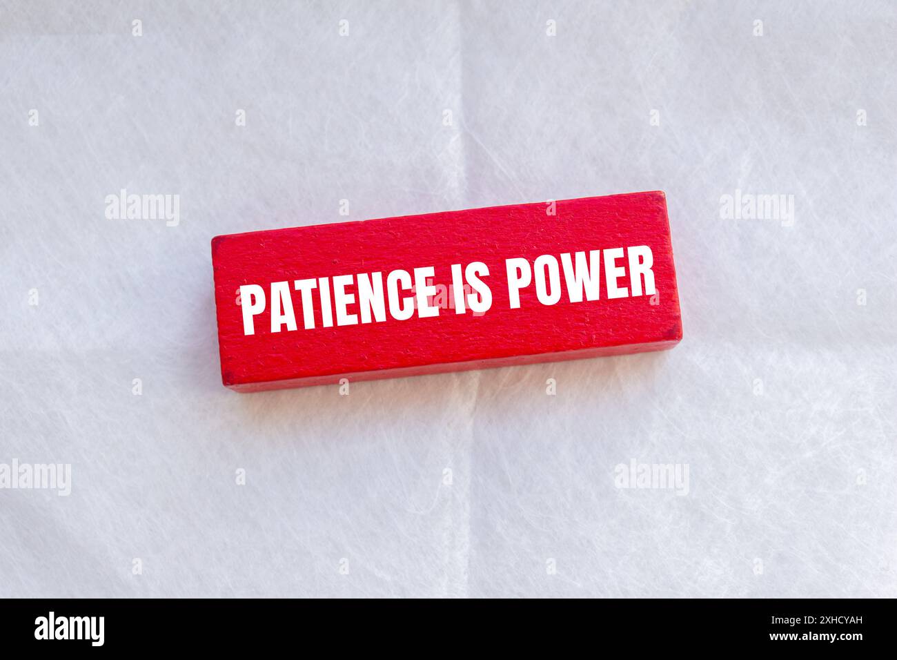 Patience is power words written on red wodoen block with white background. Conceptual patience ...