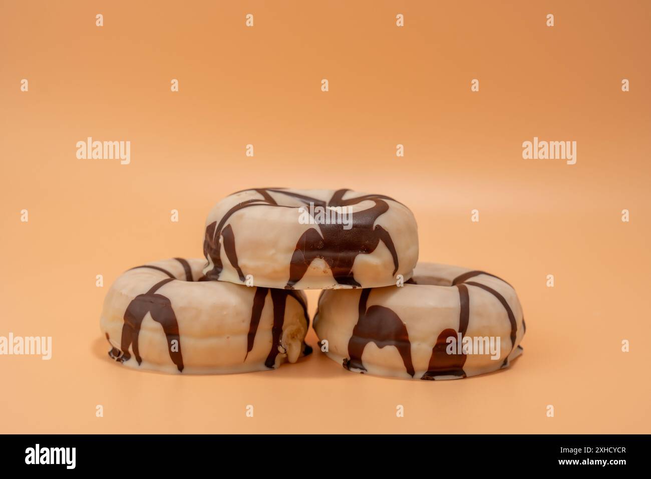 Three donuts stacked on top of each other with chocolate and vanilla ...