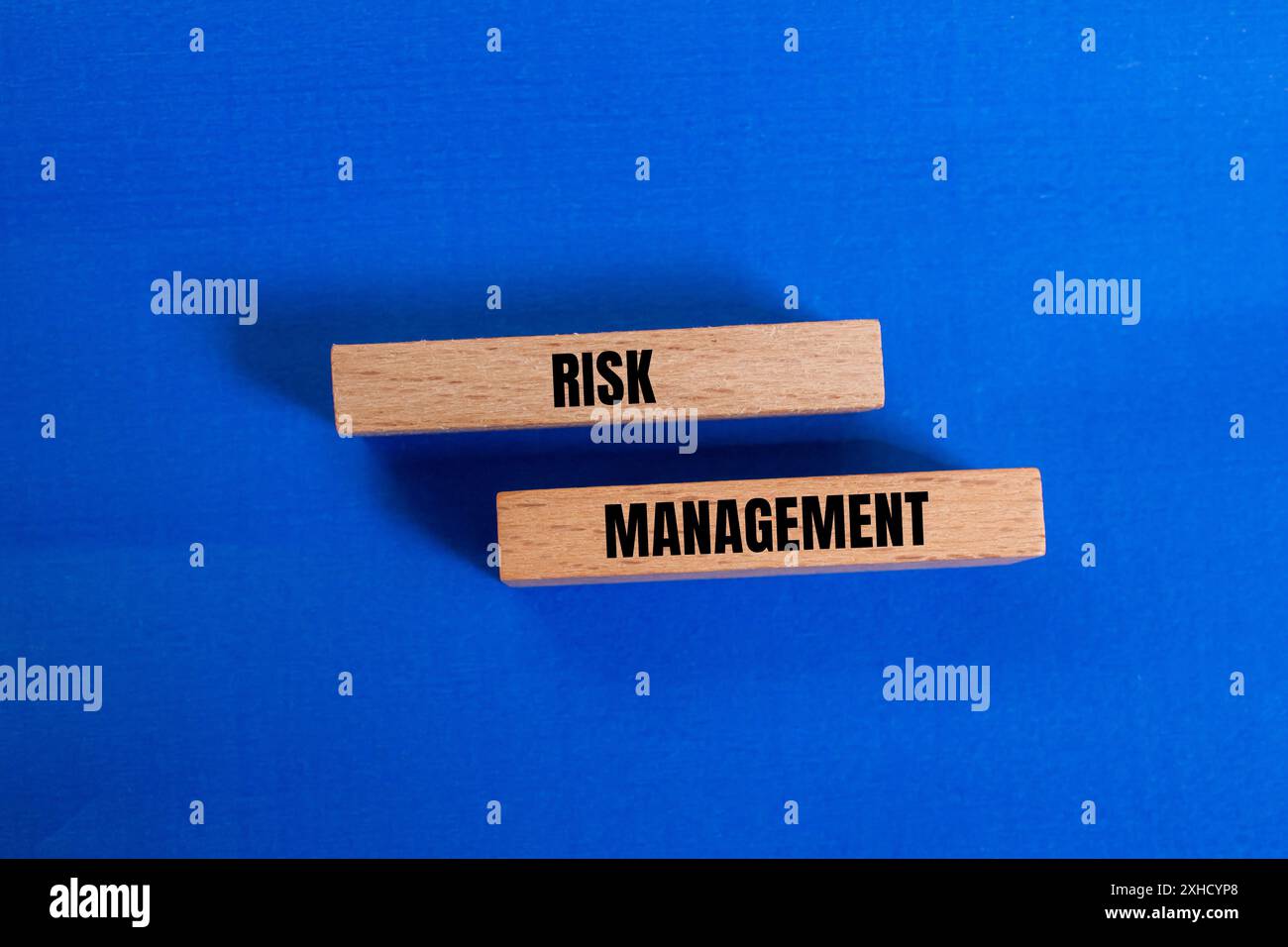Risk management message written on wooden blocks with blue background ...