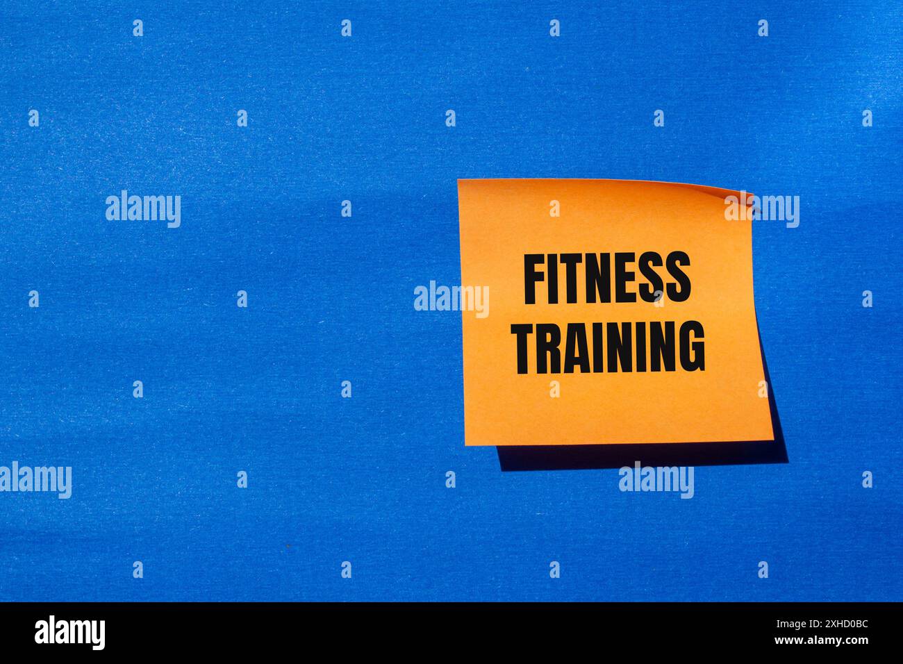 Fitness training message written on orange paper with blue background ...