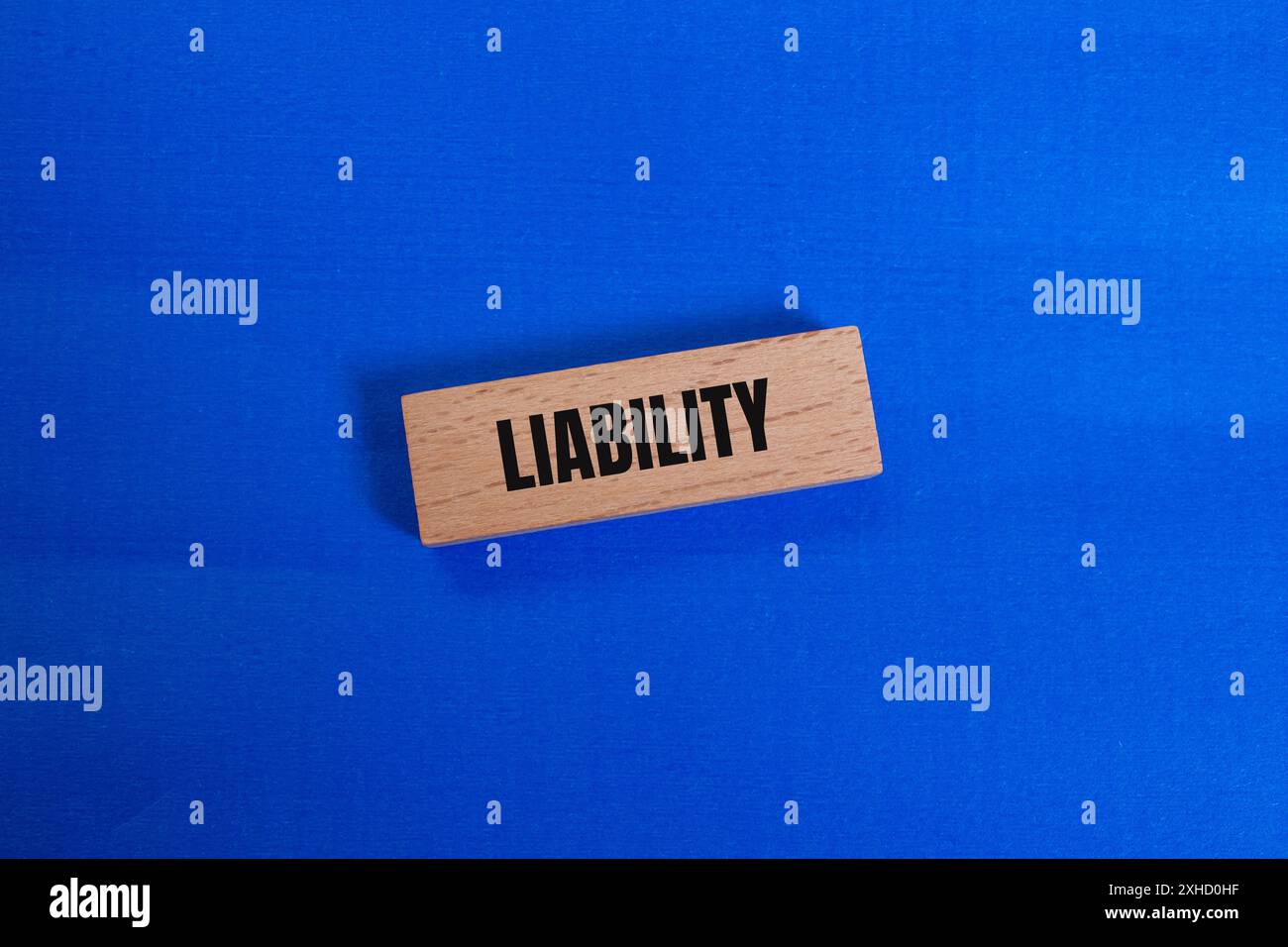 Liability message written on wooden block with blue background. Conceptual liability symbol ...