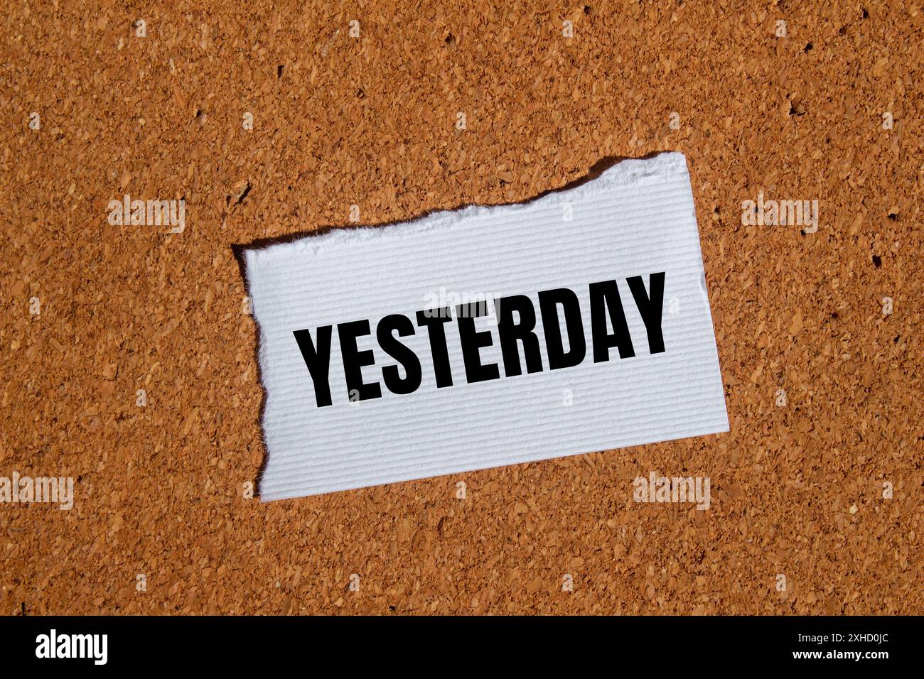 Yesterday word written on ripped white paper piece with brown ...