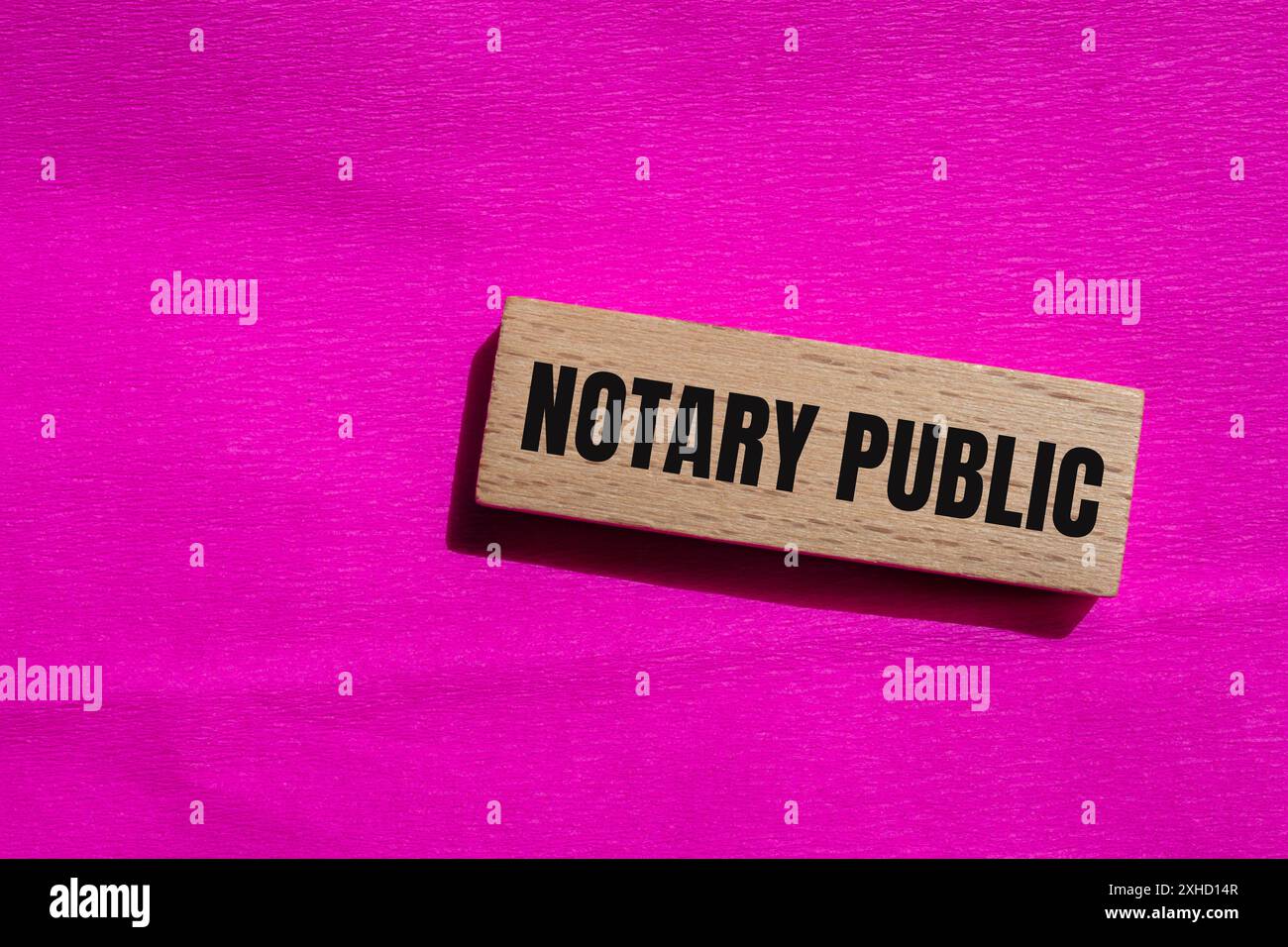 Notary public words written on wooden block with pink background ...