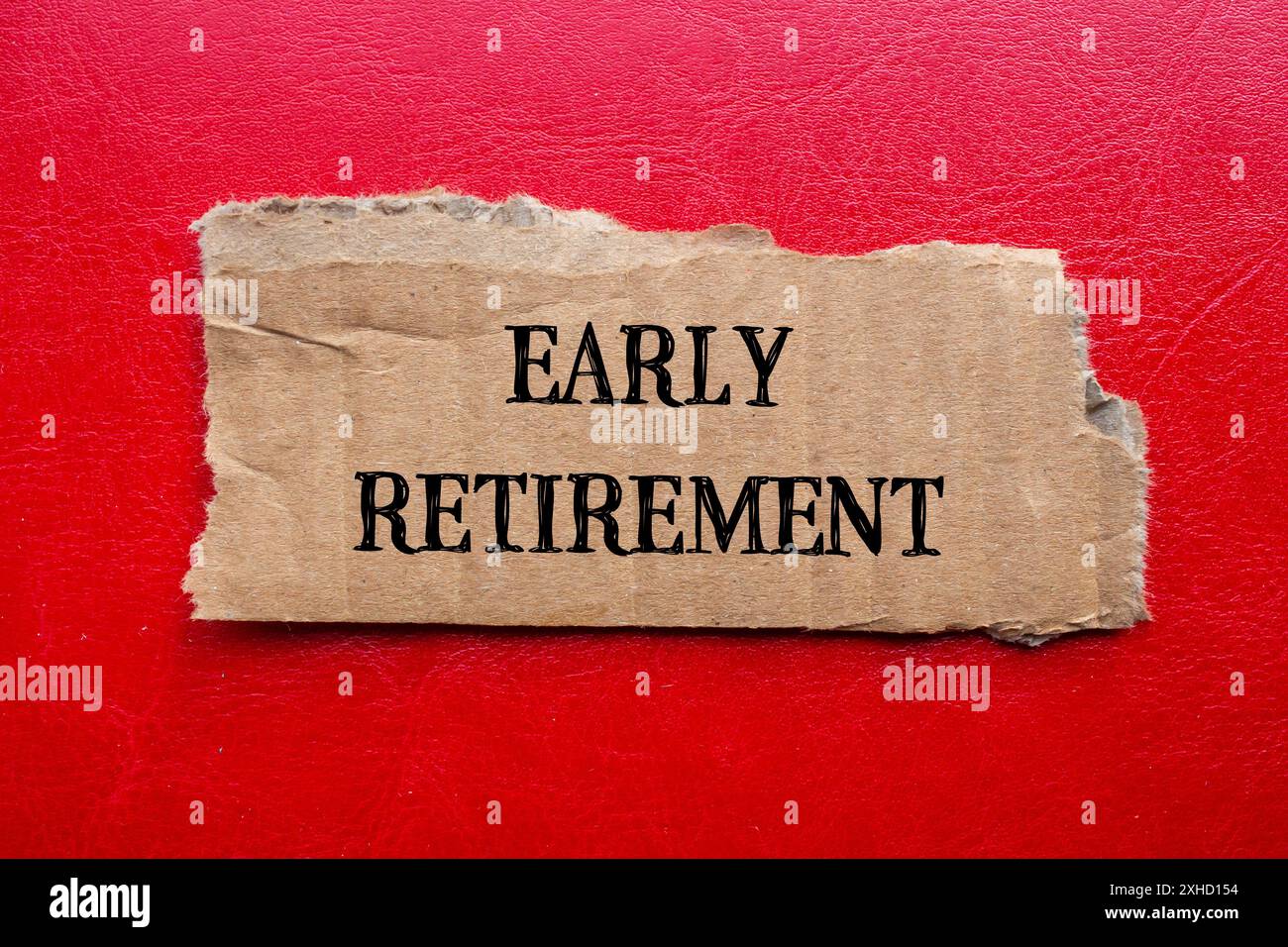 Early retirement words written on ripped cardboard paper piece with red ...