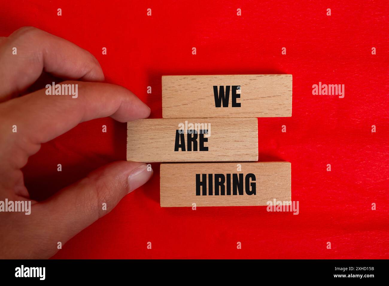 We are hiring message written on wooden blocks with color background. Conceptual we are hiring ...