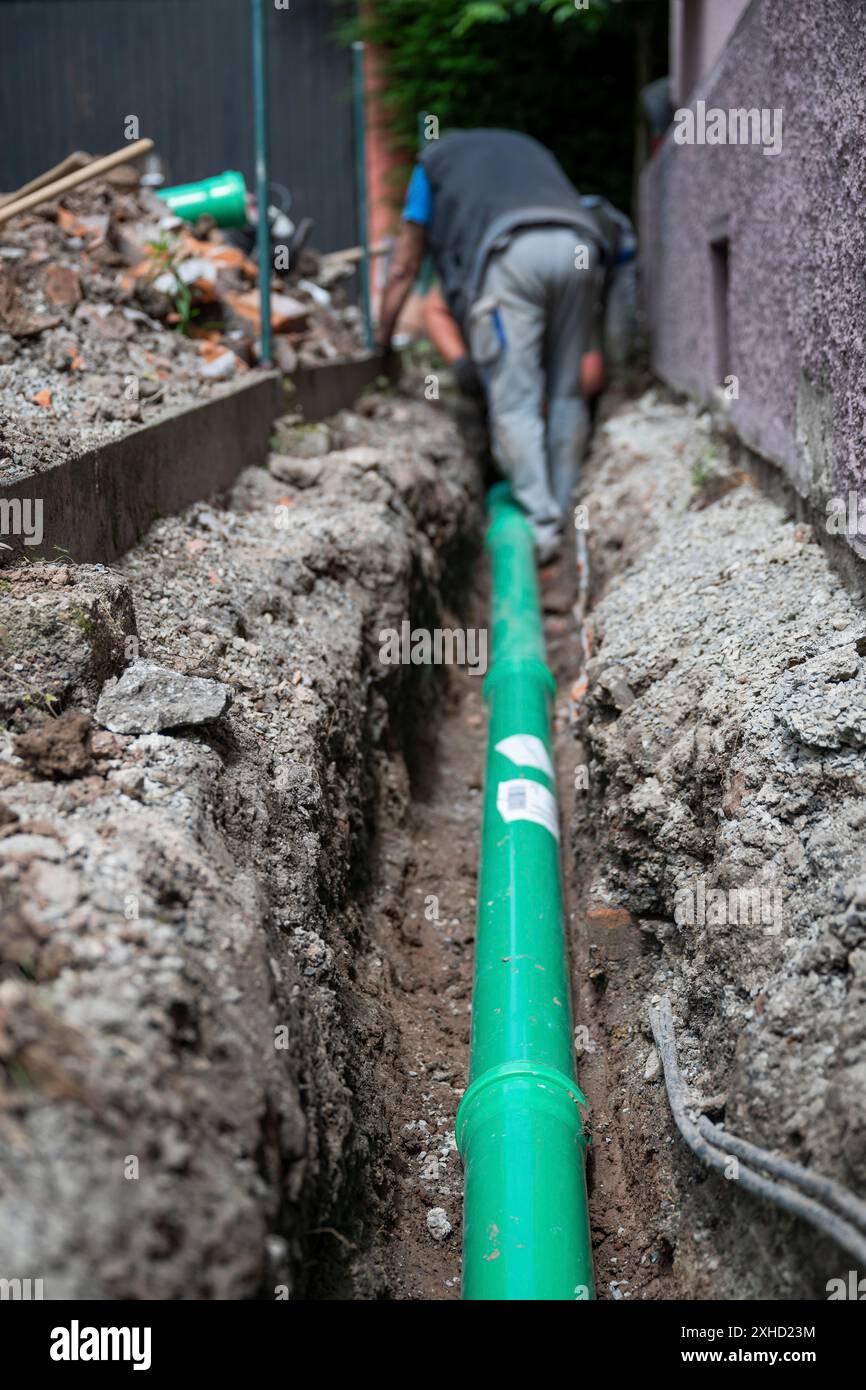 Construction worker, newly laid green sewage pipe, trench, Stuttgart ...