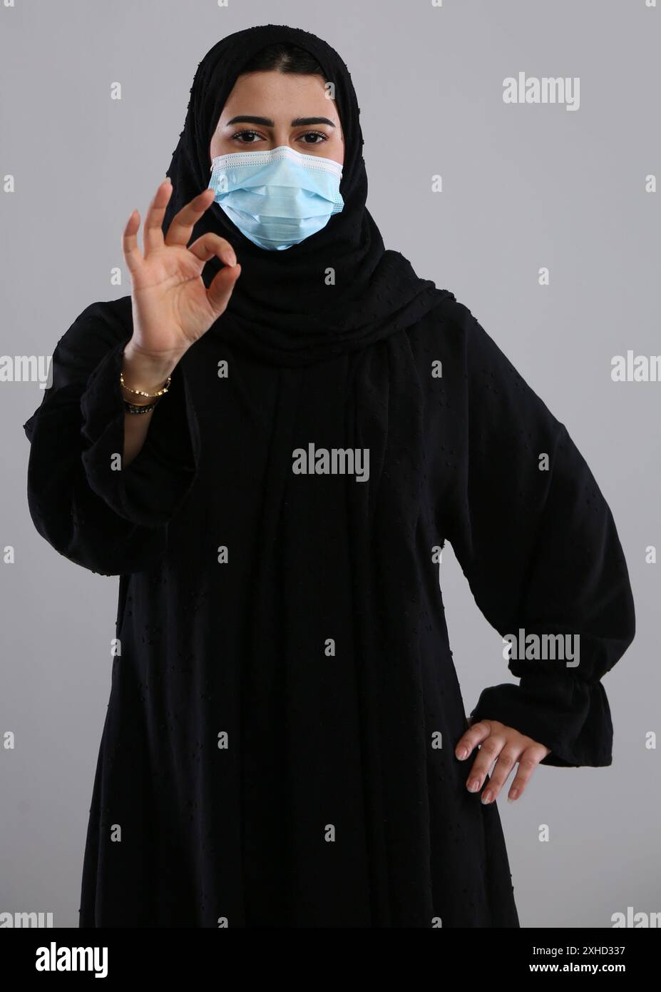 saudi arabian woman in hijaab wearing mask looking at camera with ...