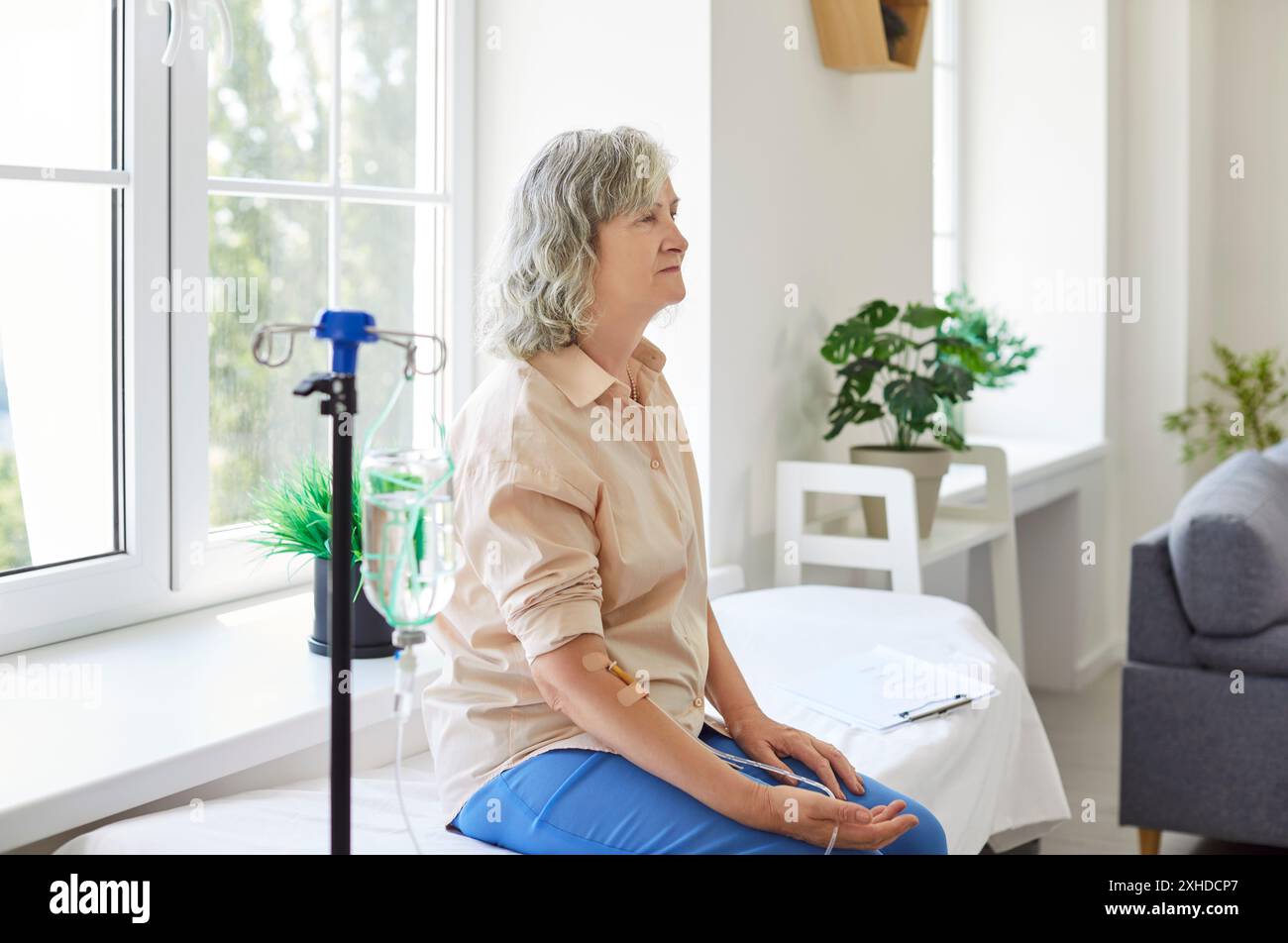 Senior woman receiving IV drip infusion and vitamin injection therapy ...