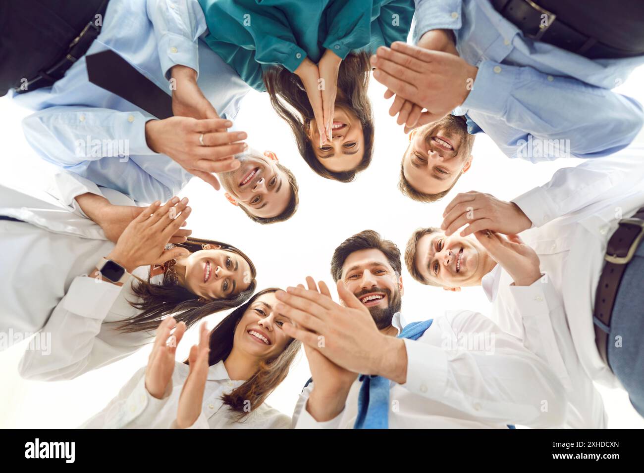 Bottom view portrait of cheerful business people looking down into ...