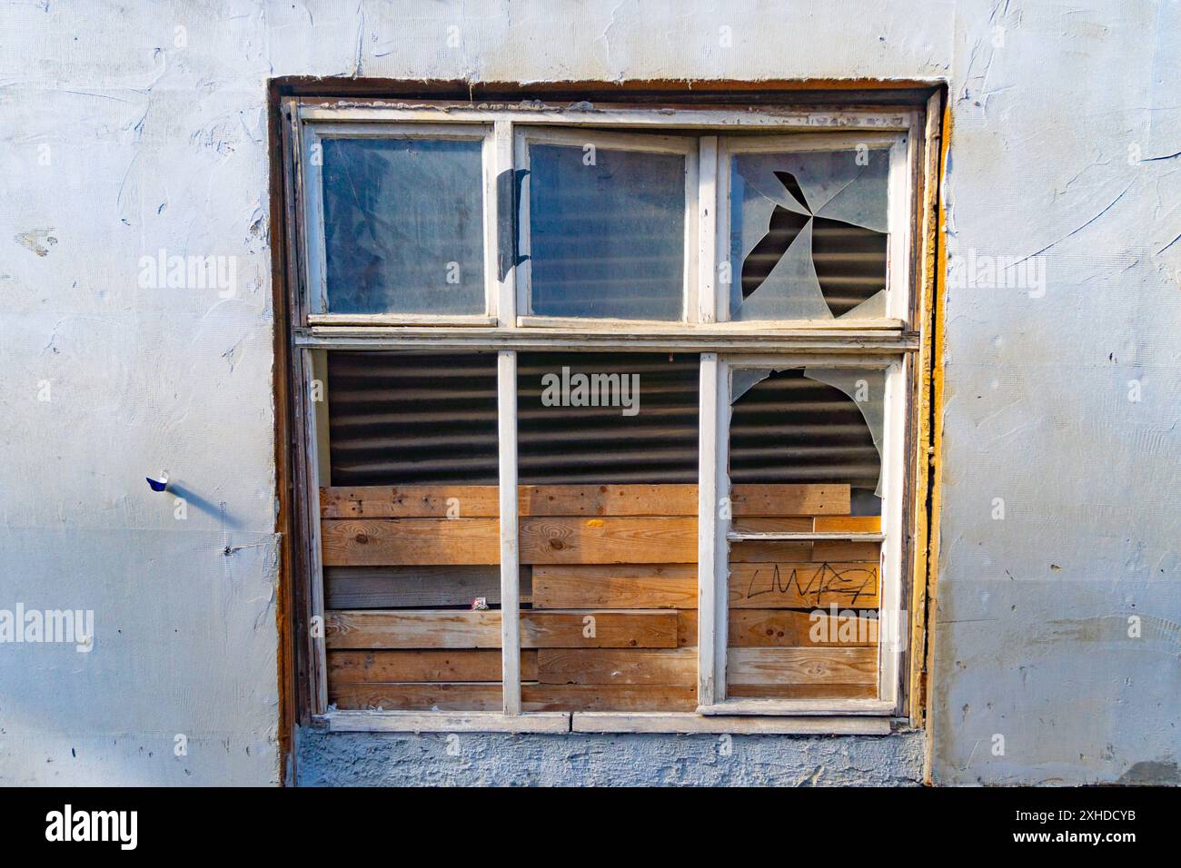 Broken window covered with brown wooden slats as a makeshift solution ...