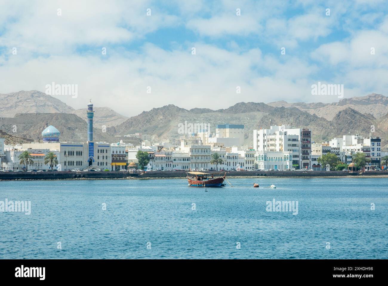 Mutrah promenade panorama with bay and traditional dhow boat anchored ...