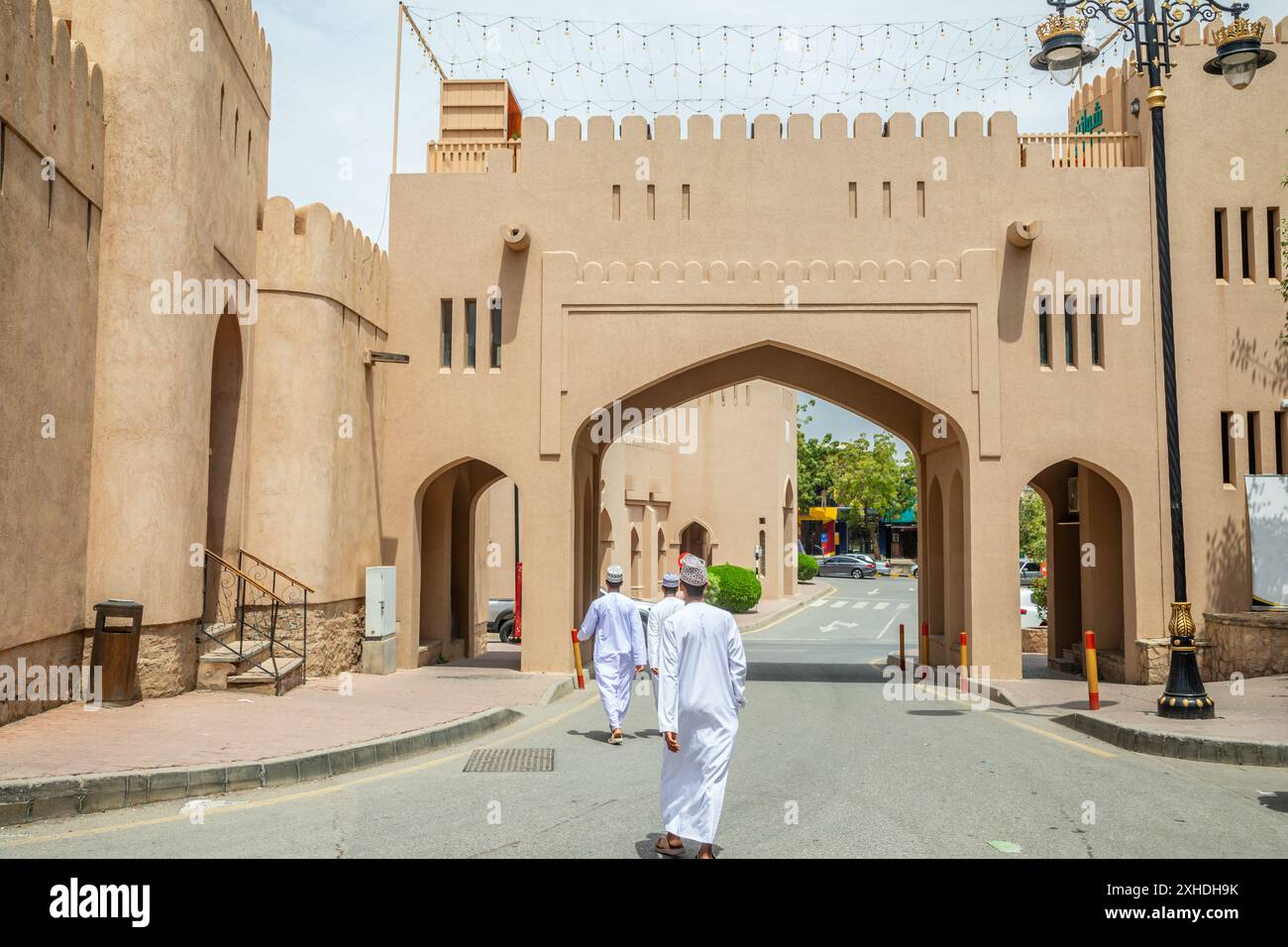 Traditionally dressed in white thobe peoples walking through the gate ...