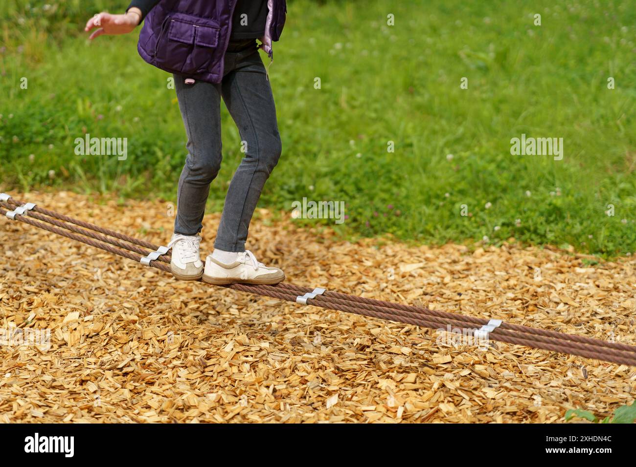 Children's legs balance on a rope. Children's feet in shoes close-up ...