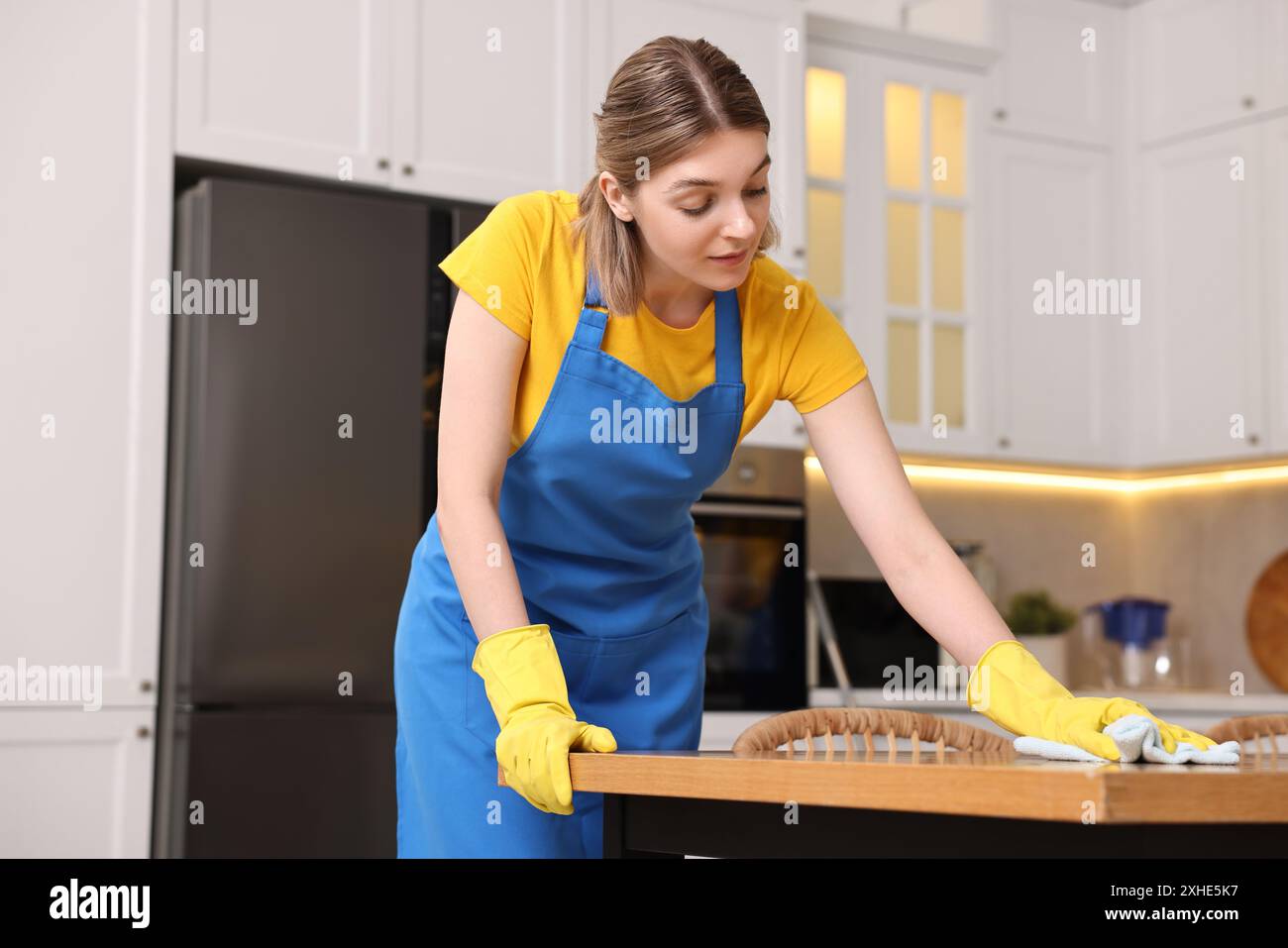 Professional janitor wearing uniform cleaning table in kitchen Stock ...