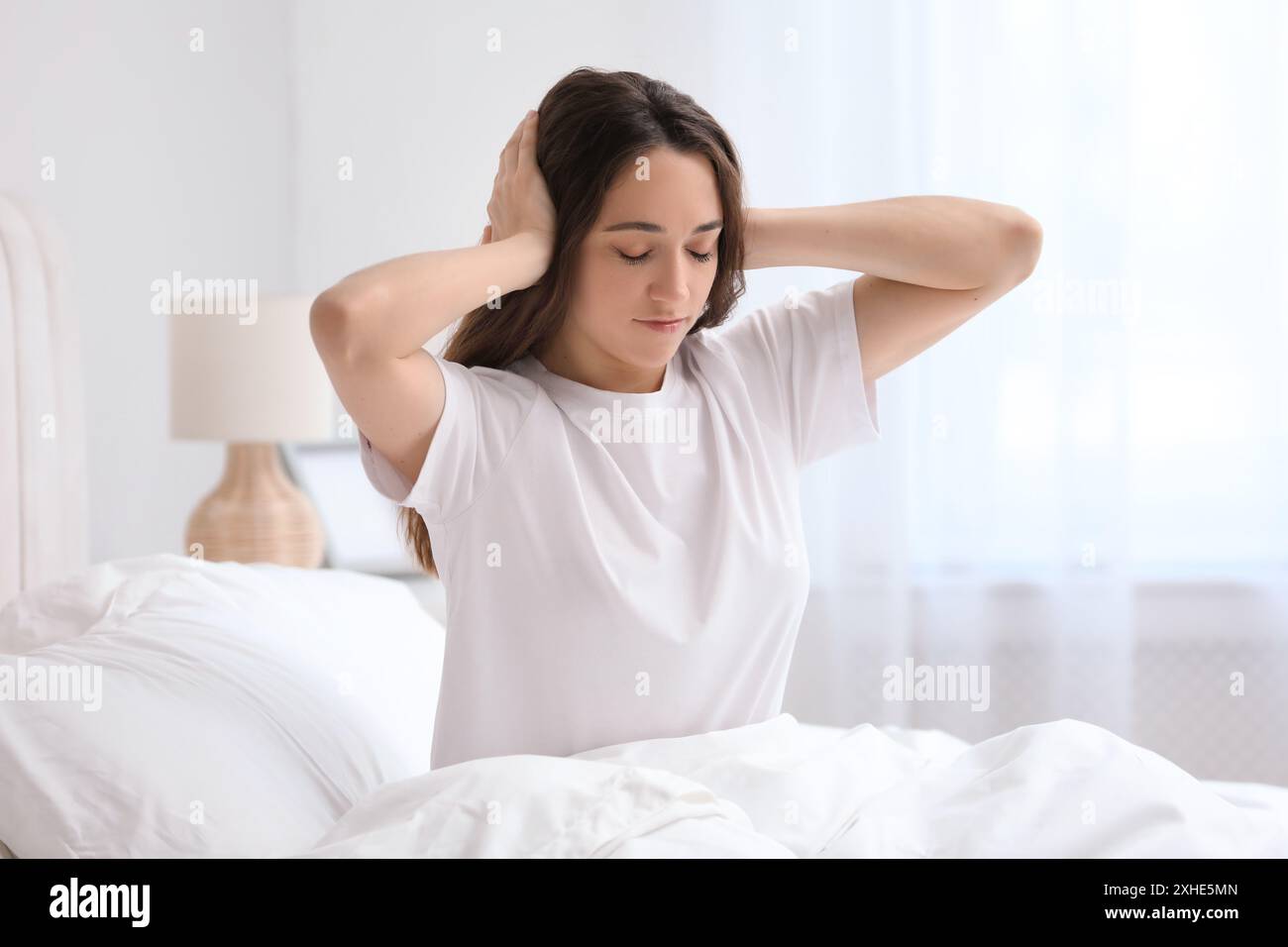 Woman covering ears in bed hi-res stock photography and images - Alamy