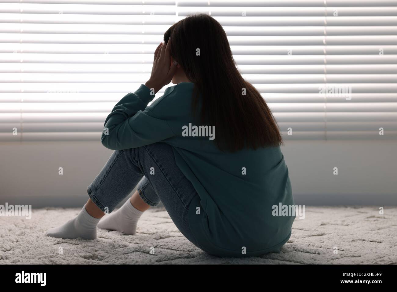 Loneliness concept. Sad woman sitting on floor at home, back view Stock ...
