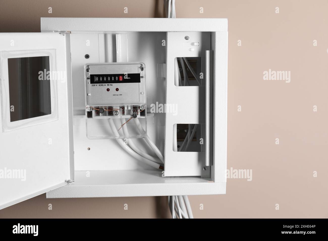 Electric meter in fuse box on beige wall. Energy measuring device Stock ...