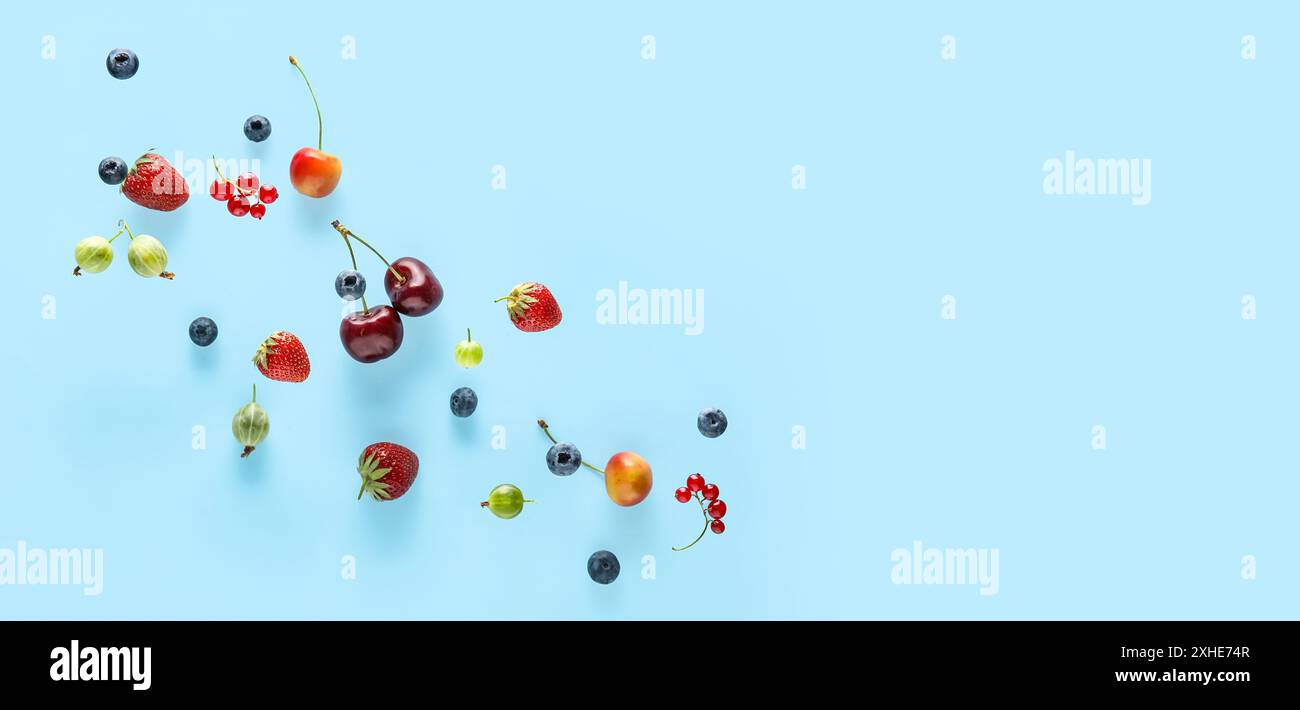 Different flying berries on light blue background with space for text ...