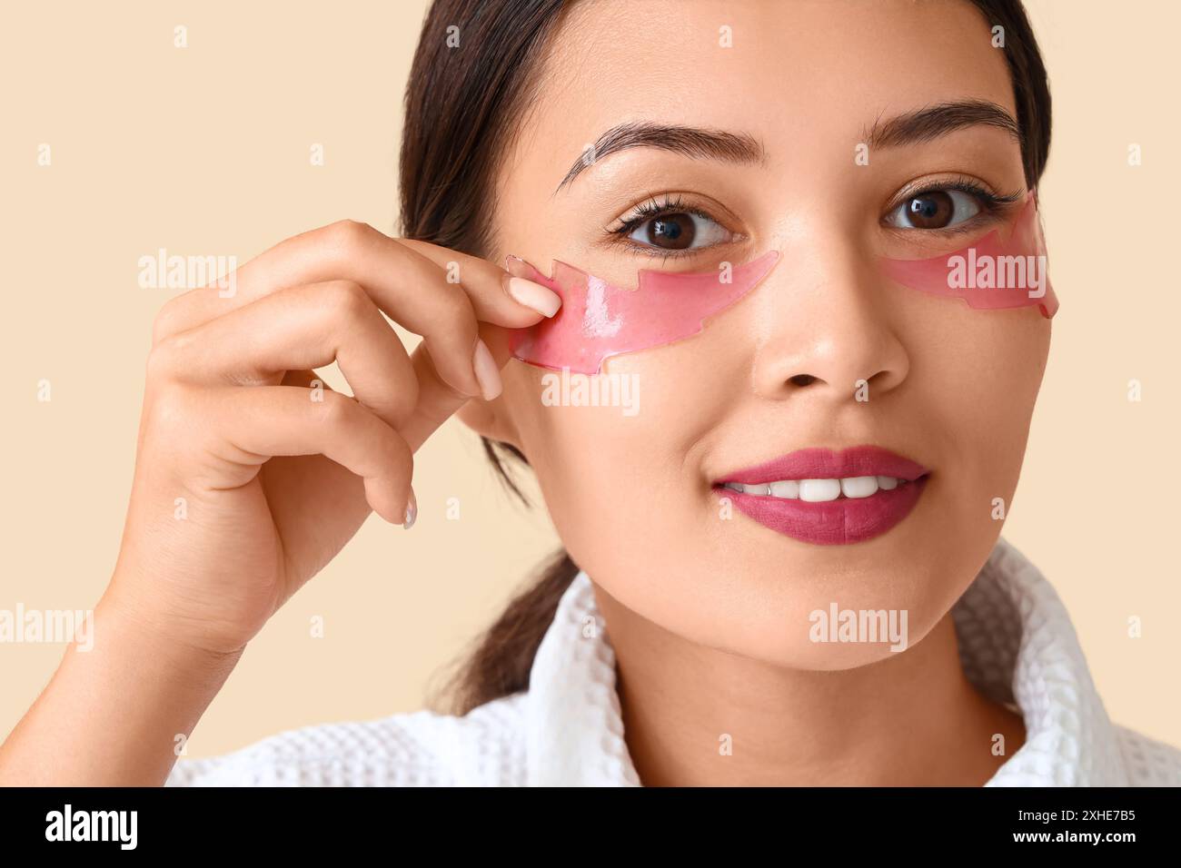 Beautiful young woman with under-eye patches on beige background Stock ...