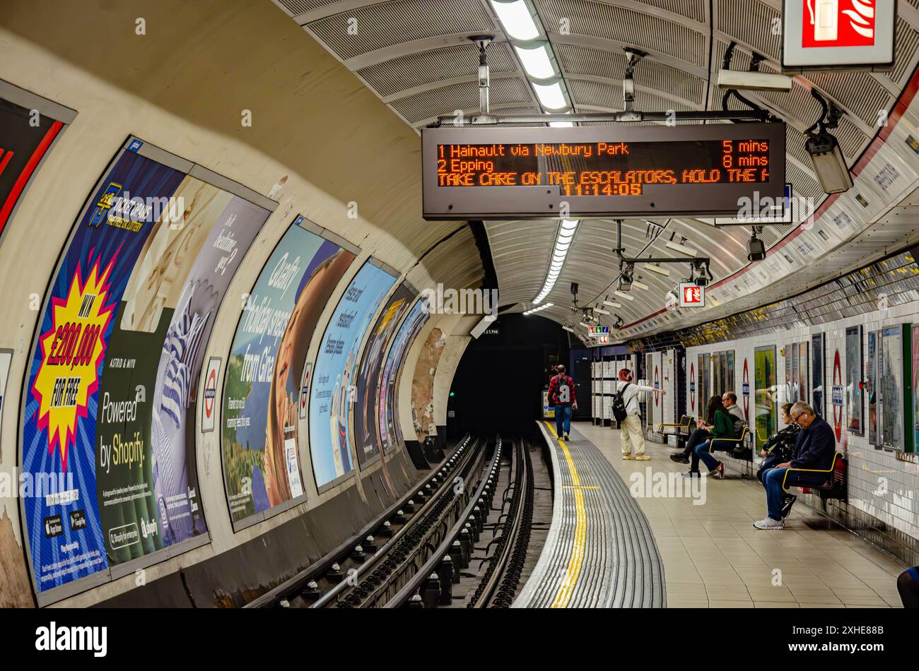 Passengers wait on the platform at Shepherds Bush London Underground ...
