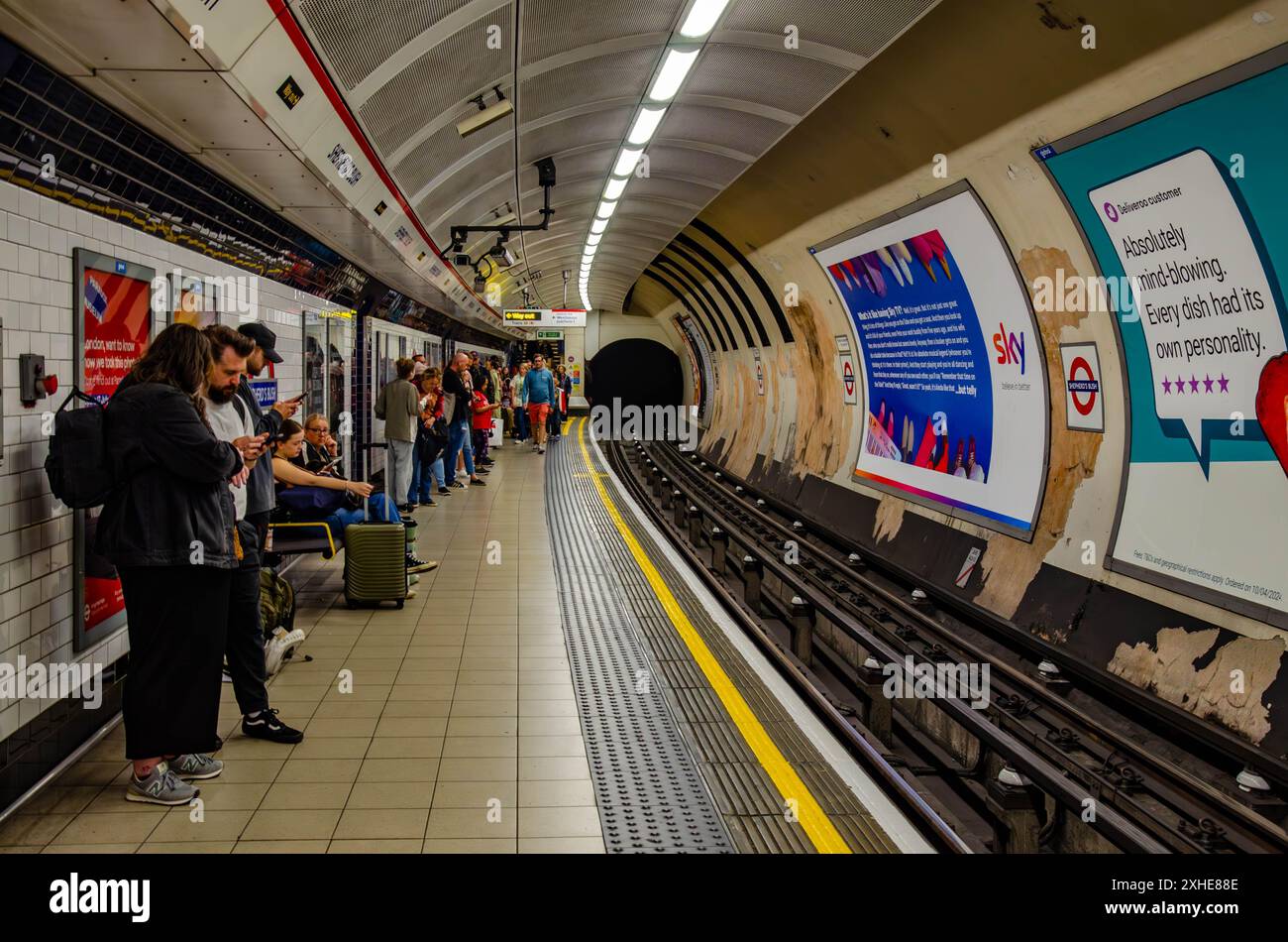 Passengers wait on the platform at Shepherds Bush London Underground ...