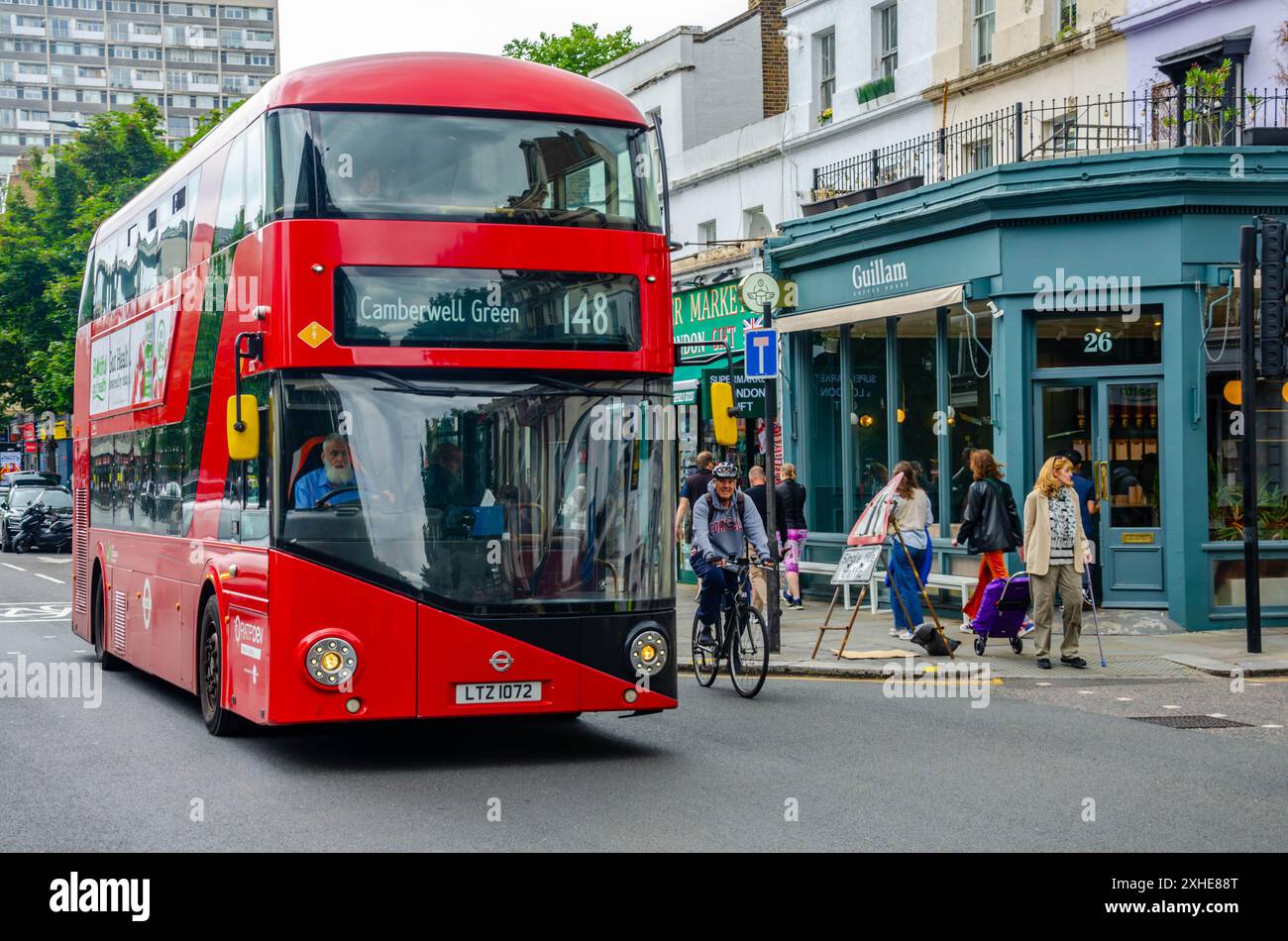 The no. 148 red double decker bus to Camberwell Green passes a cyclist ...