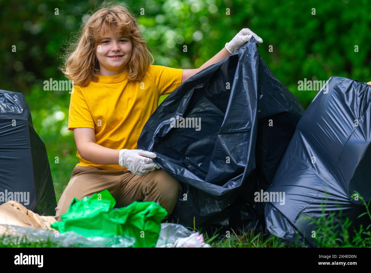 Child boy picking up plastic bottle outdoor. Save environmental and ...