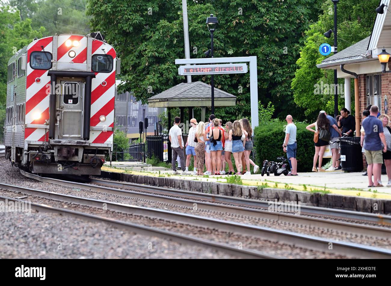 Glen Ellyn, Illinois, USA. Waiting commuter passengers gather as their ...