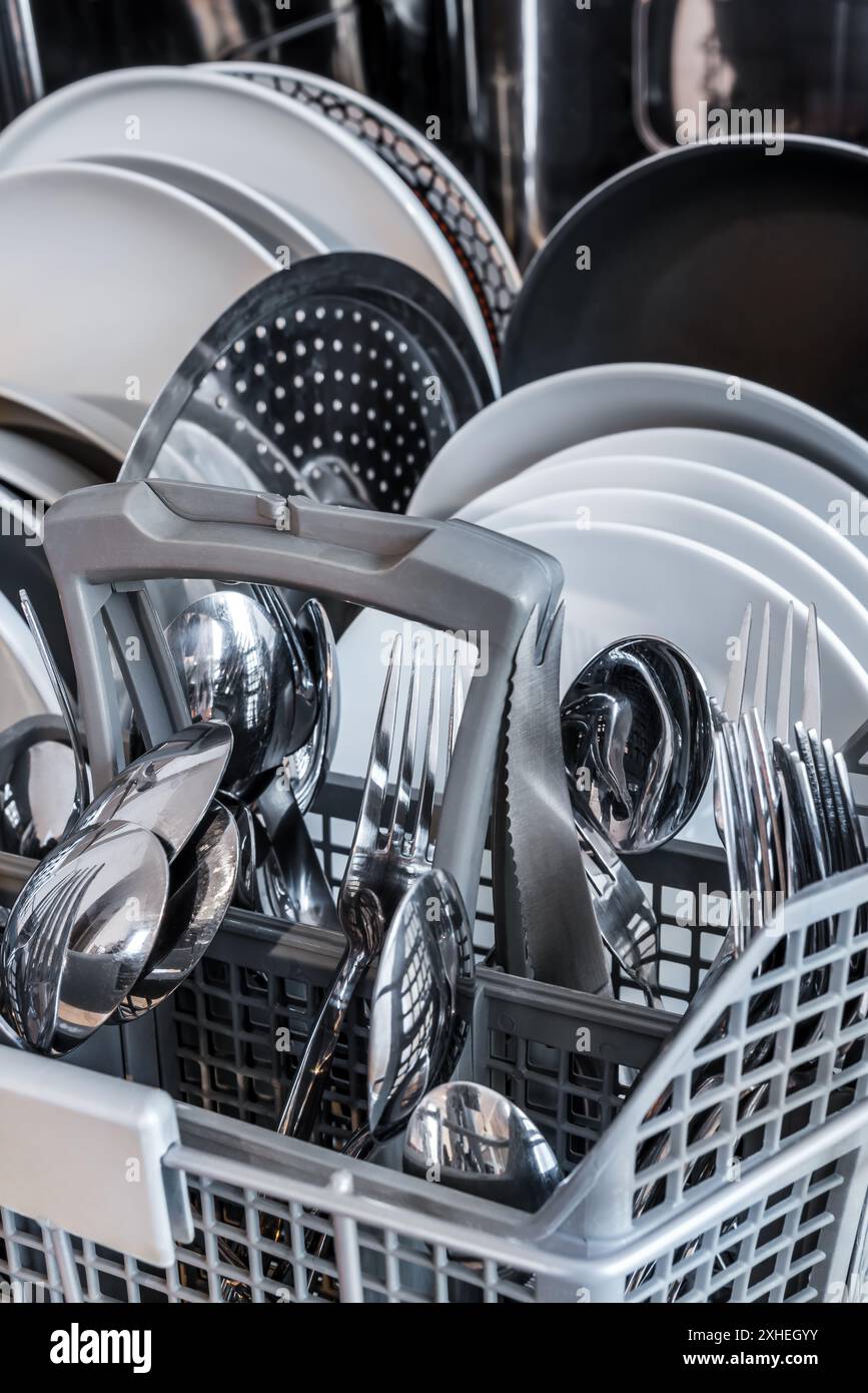 Open Dishwasher Close-up Full Of Plates, Cutlery, And Other Kitchen ...