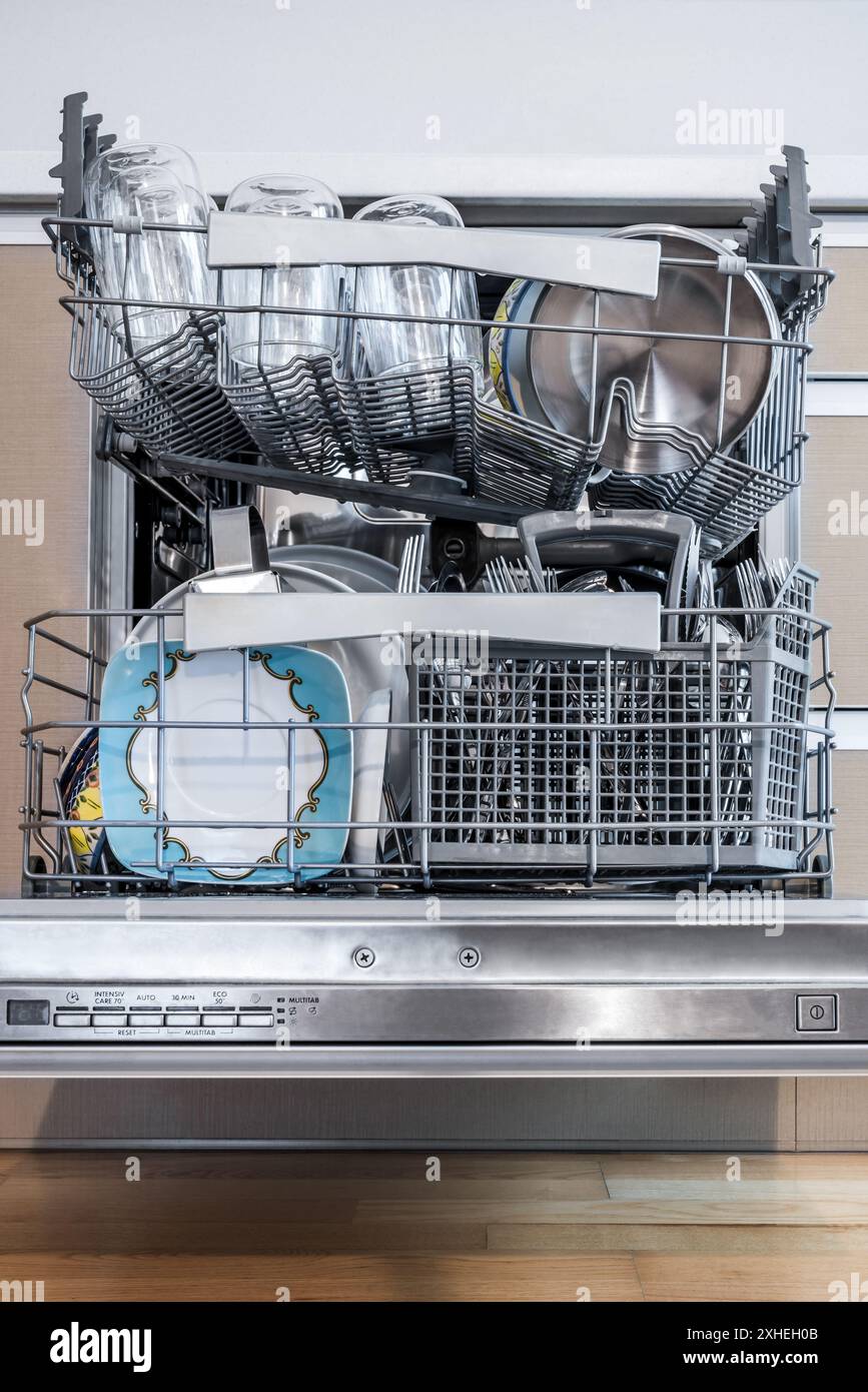 Open Dishwasher Full Of Plates, Cutlery, Glasses And Other Kitchen ...