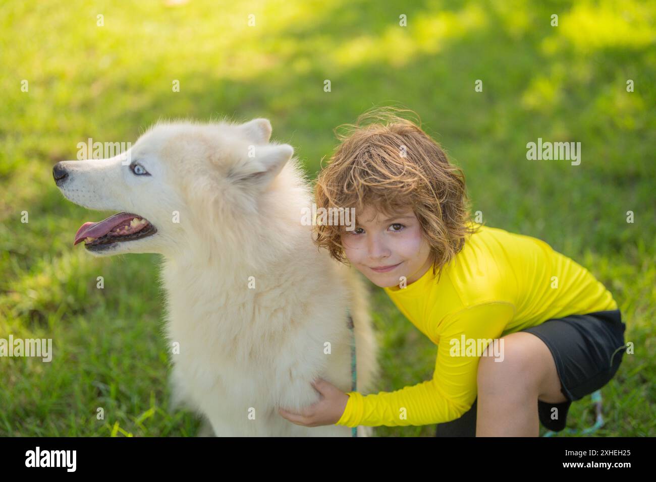 Child and dog outdoor portrait. Kid hugging dog in the summer park. Kid ...