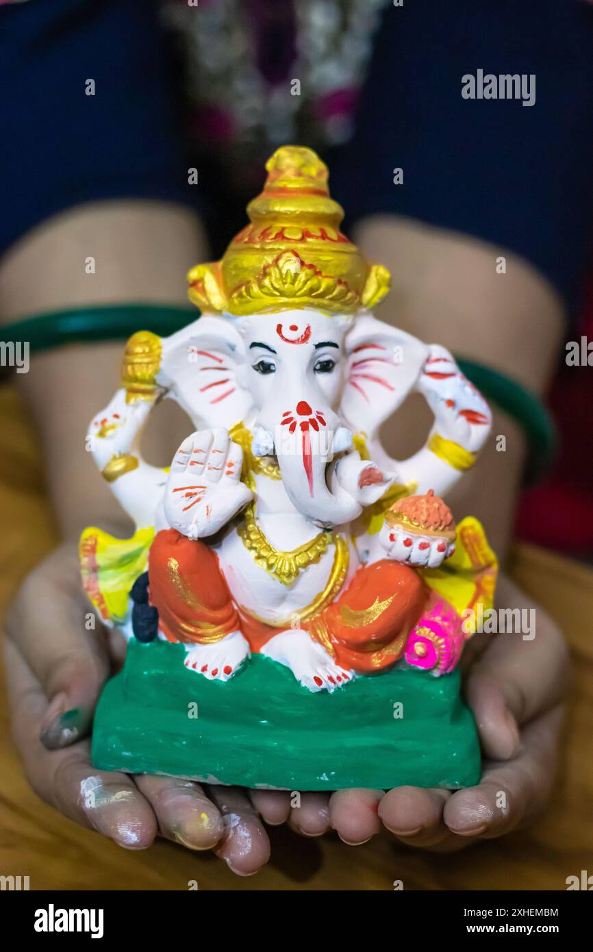 devotee holding the hindu holy god ganesha idol in hand from flat angle ...