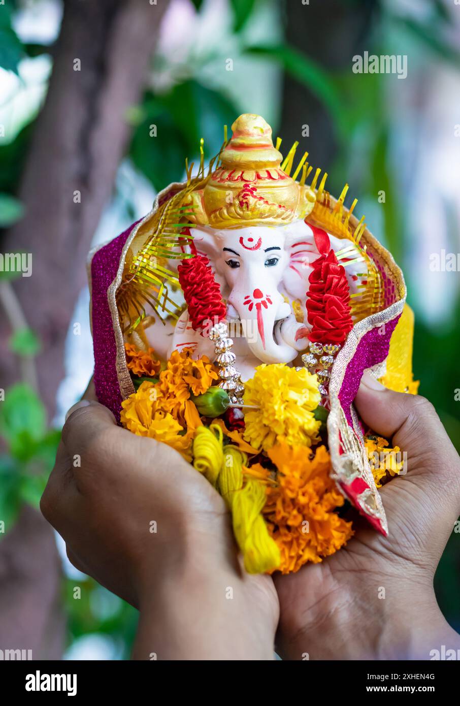 devotee holding the hindu holy god ganesha idol in hand from flat angle ...