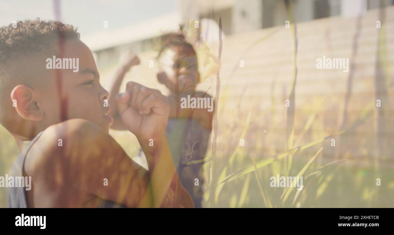 Image of grasses over happy diverse schoolboys stretching in outdoor ...