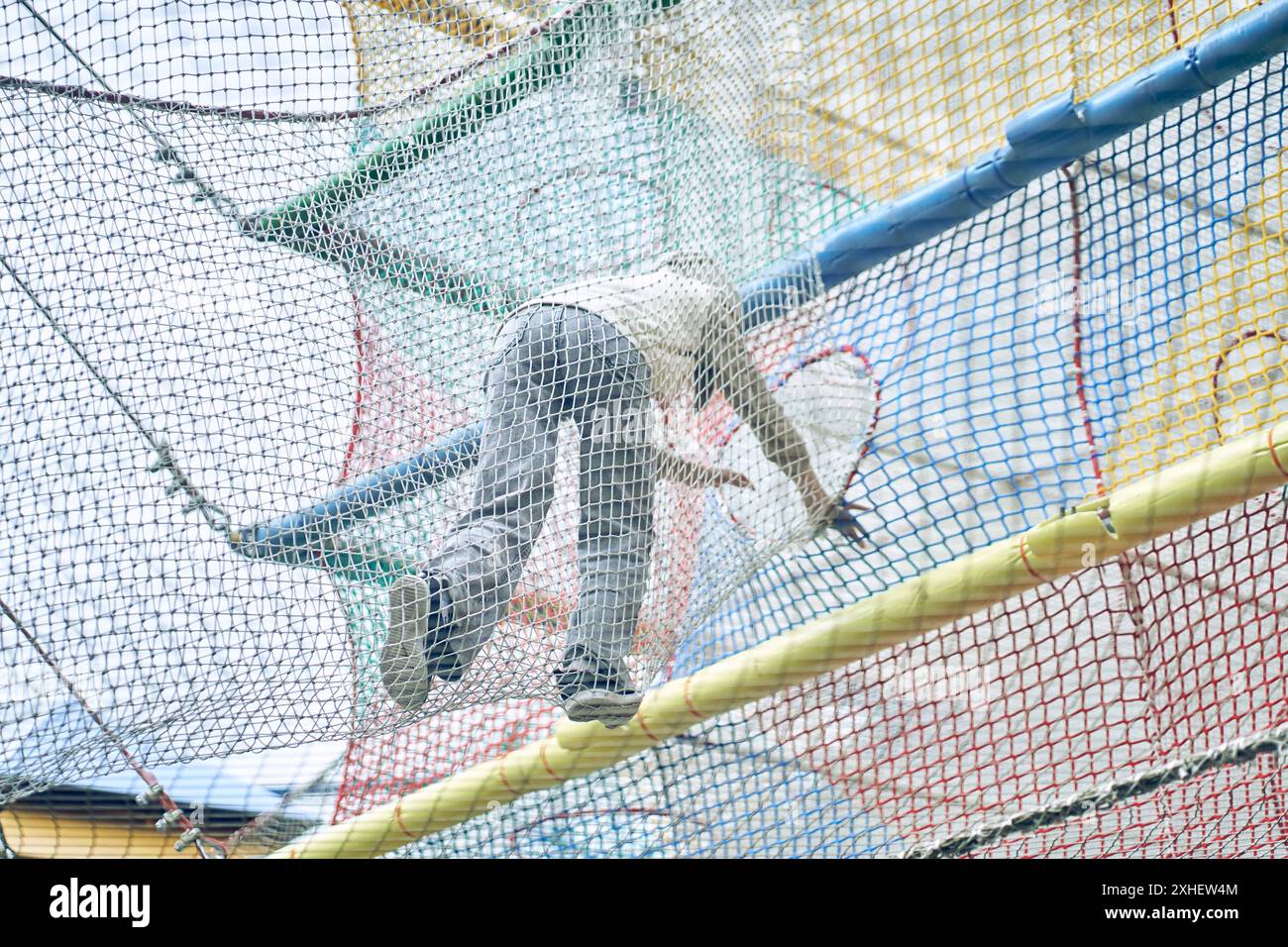 An unrecognizable girl overcoming a rope obstacle course on a ...