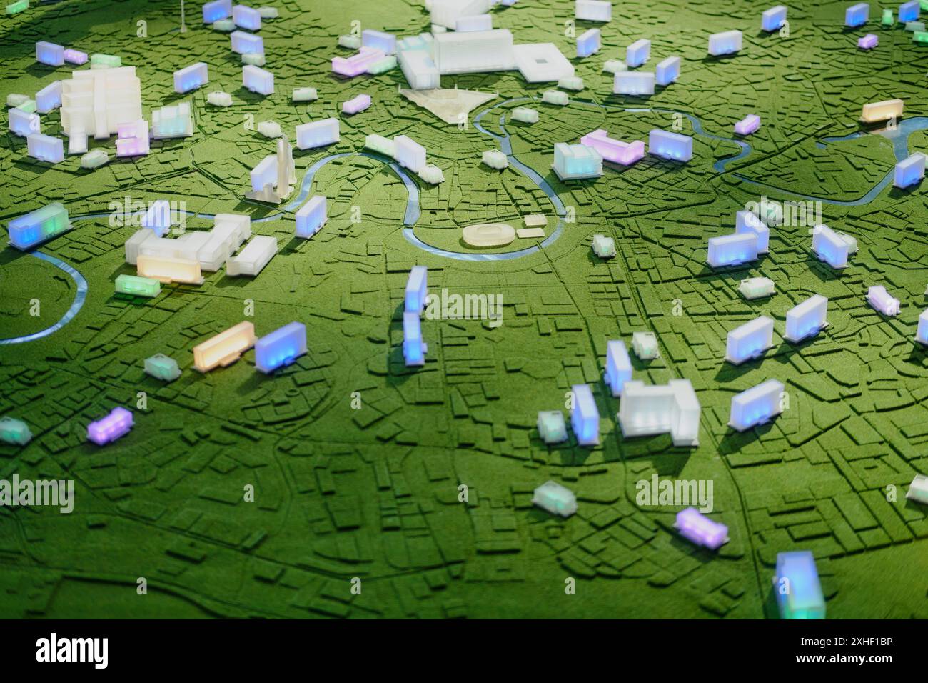 Miniature cityscape model with illuminated buildings on a green ...