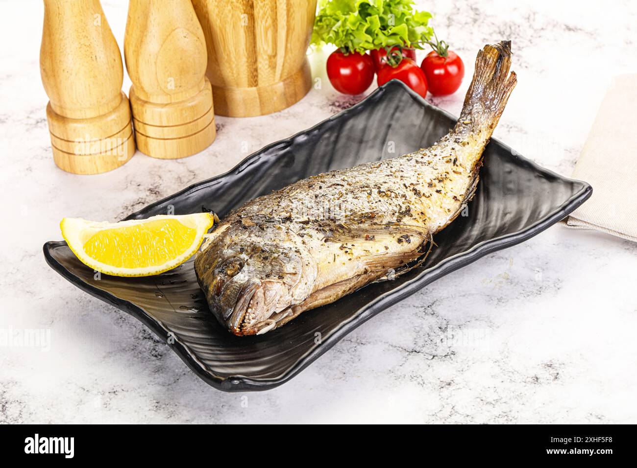 Baked Dorado fish served lemon slice Stock Photo - Alamy