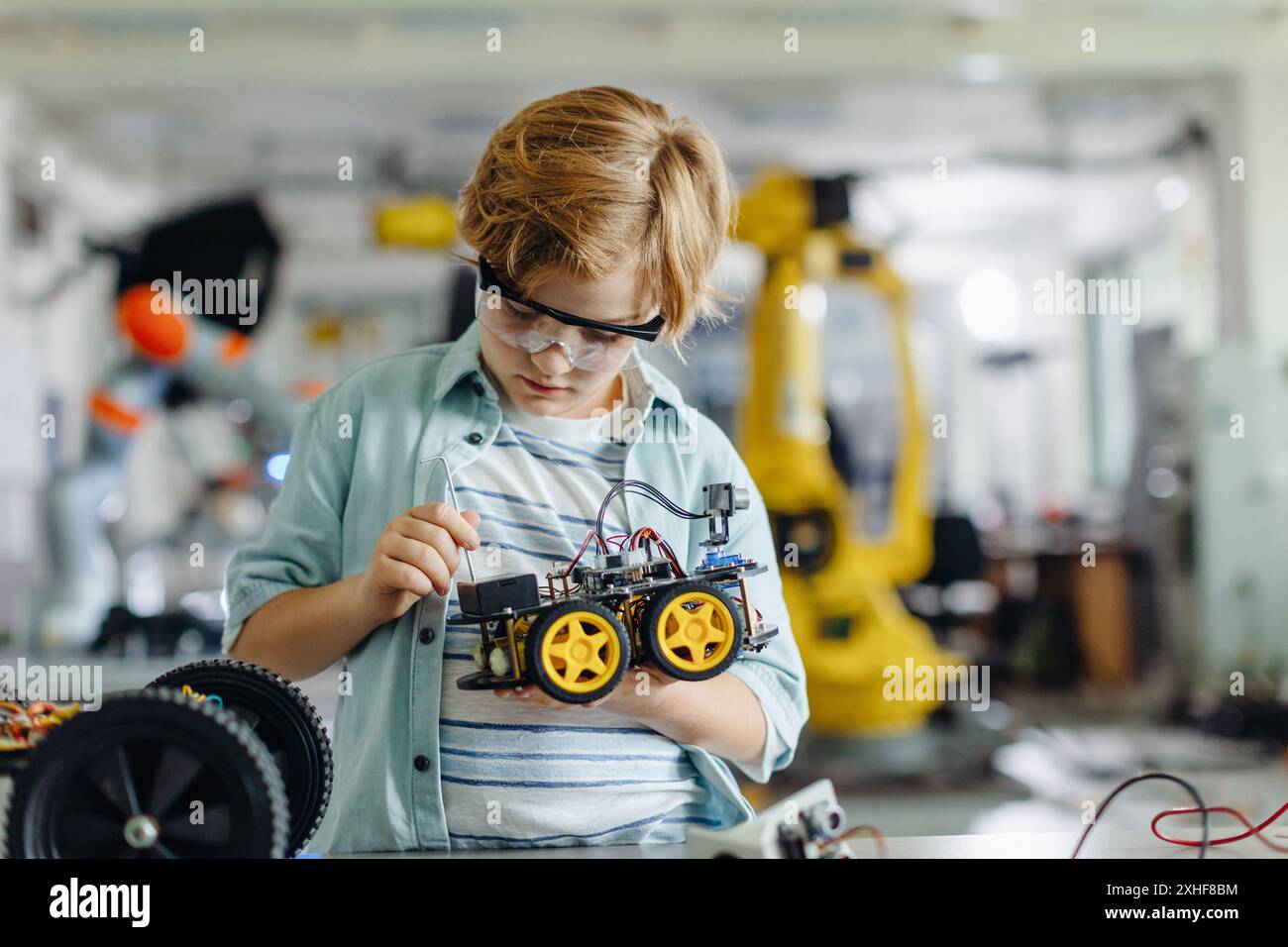 Portrait of schoolboy building robotic car in after-school robotics ...