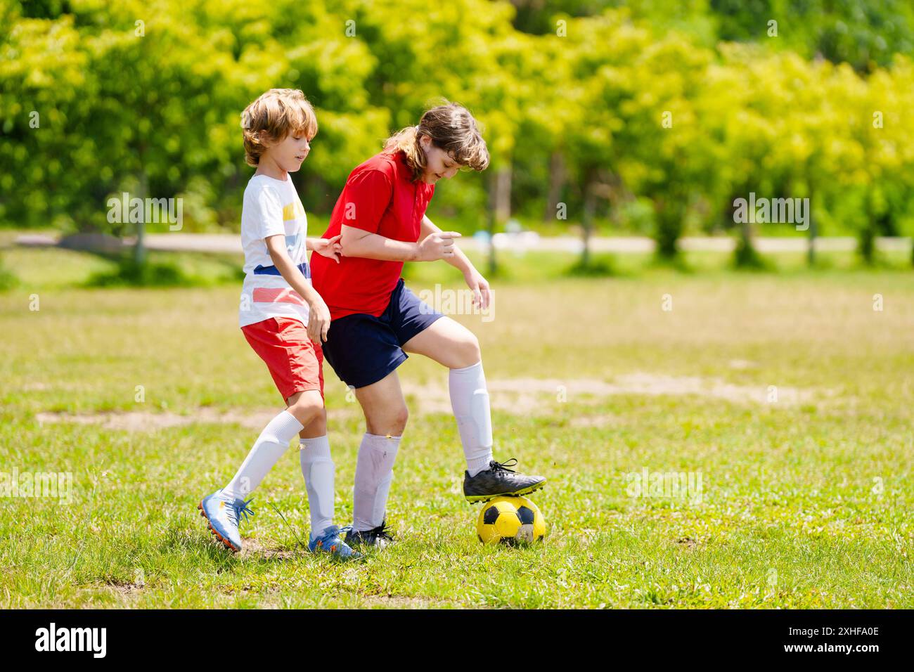 Child playing football. Kids play soccer on outdoor pitch. Little boy ...
