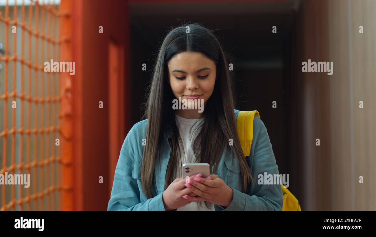 Happy smiling Caucasian student girl smile using mobile phone win ...