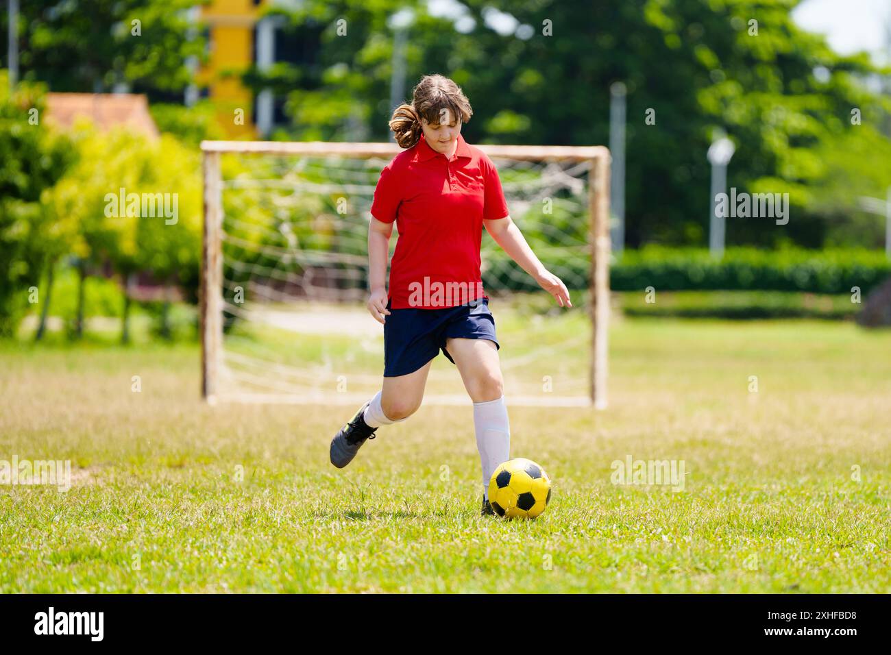 Child playing football. Kids play soccer on outdoor pitch. Teenage girl ...