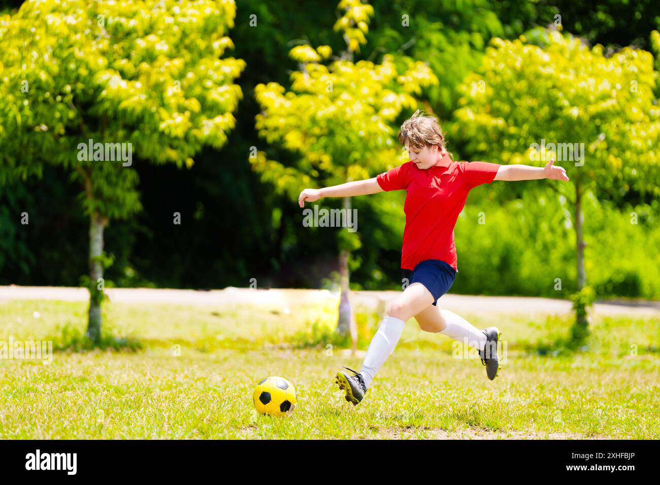 Child playing football. Kids play soccer on outdoor pitch. Teenage girl ...