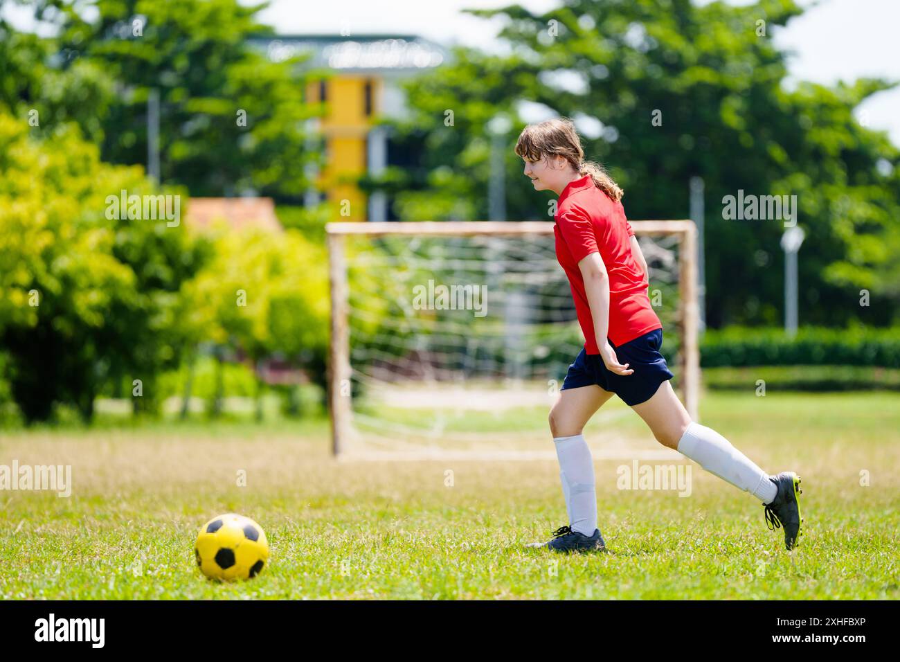 Child playing football. Kids play soccer on outdoor pitch. Teenage girl ...