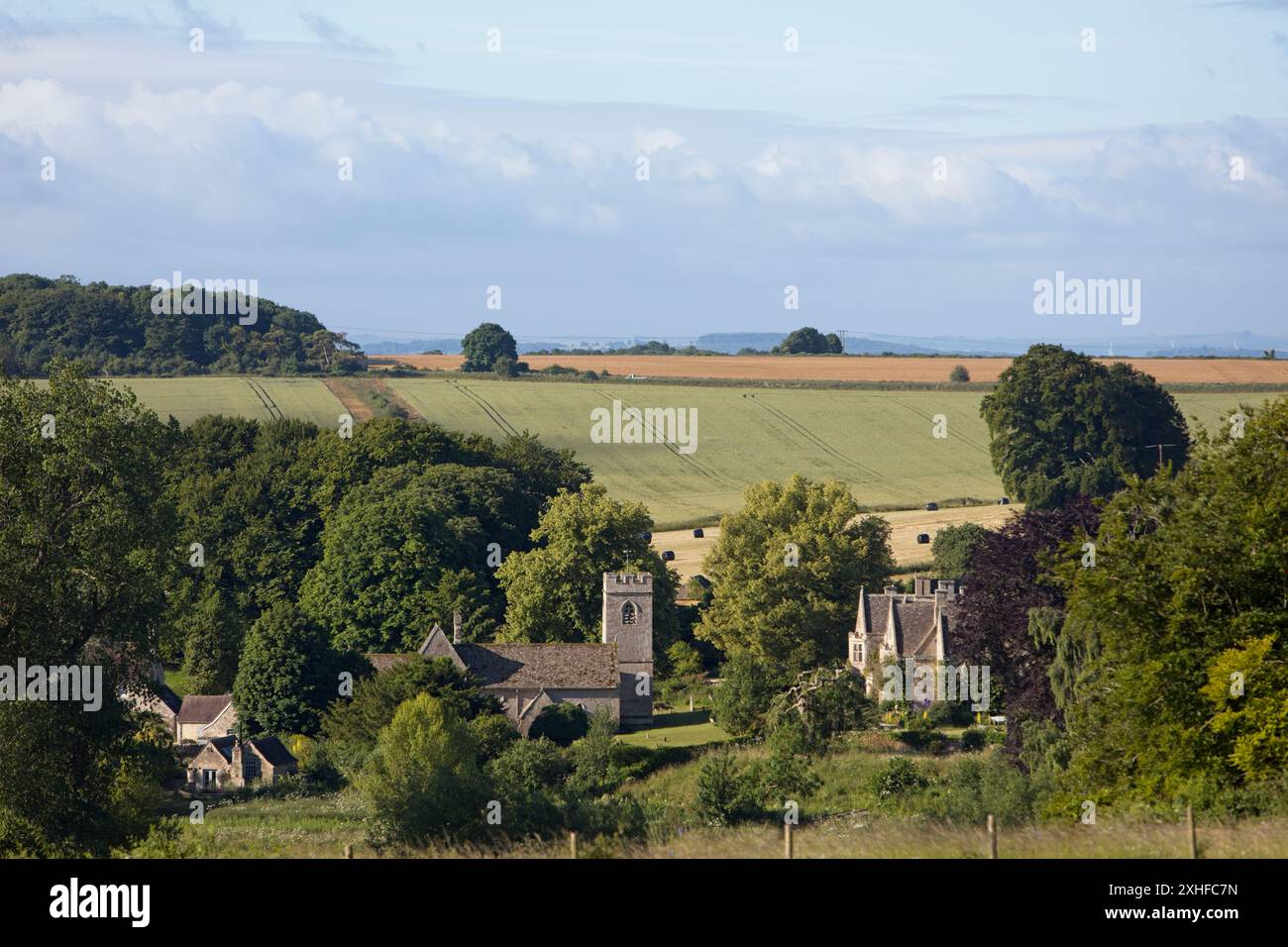 A view across Asthall showing the A40 road on the brow of the hill and ...