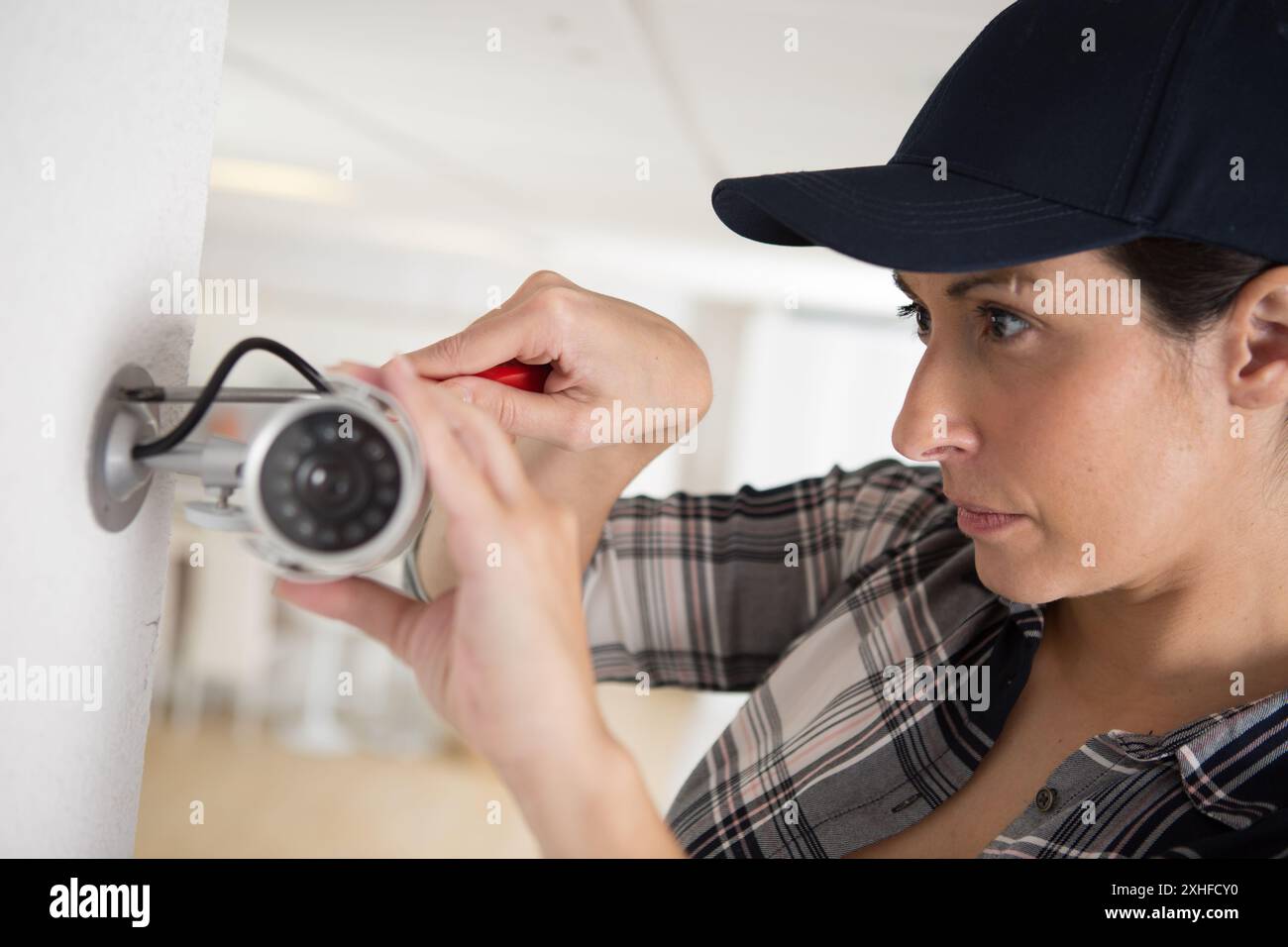 female cctv installer checking security camera Stock Photo - Alamy