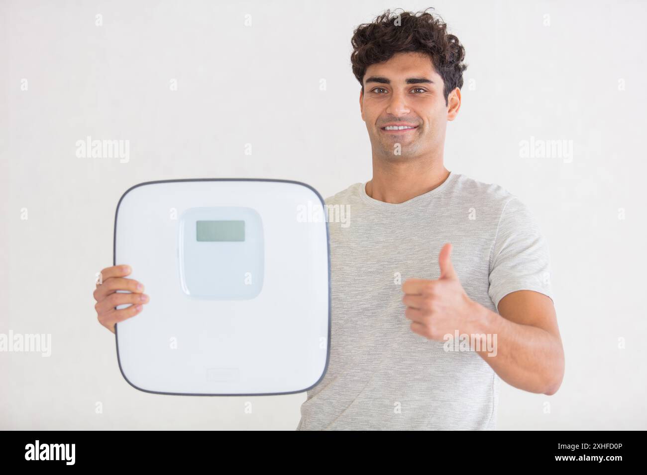 happy fitness man holding weight scales showing thumbs up Stock Photo ...