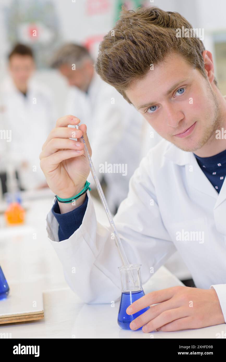 Science student holding pipette and glass flask Stock Photo - Alamy