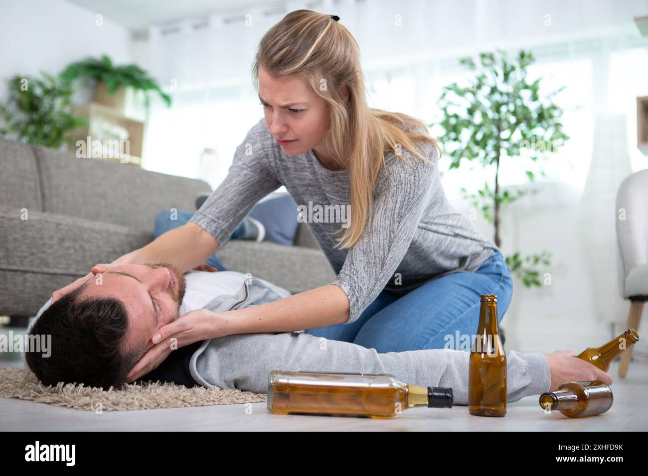 man lying drunk passed out woman trying to get contact Stock Photo - Alamy